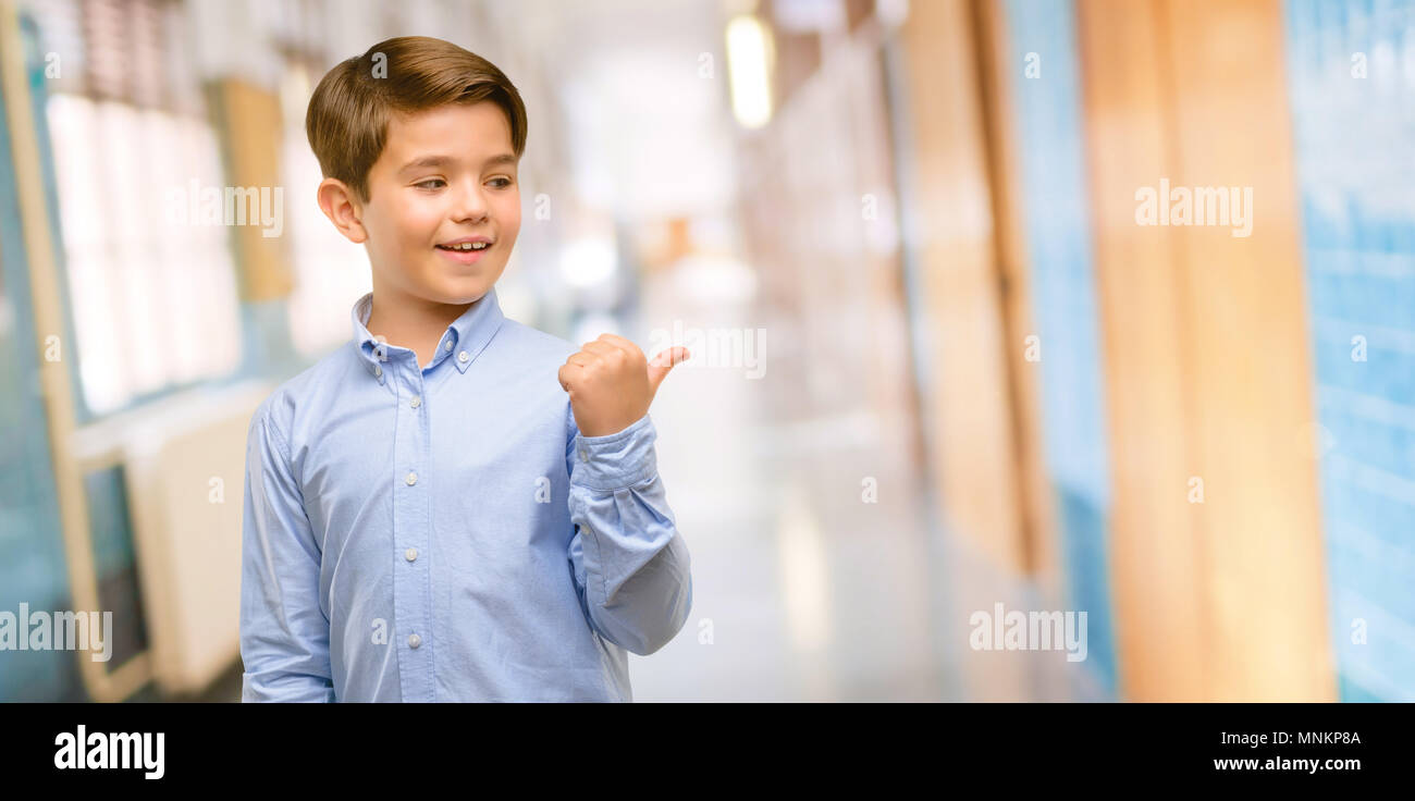 Handsome toddler child with green eyes pointing away side with finger ...