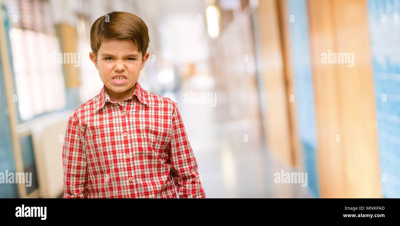 Handsome toddler child with green eyes angry and stressful frowns face ...