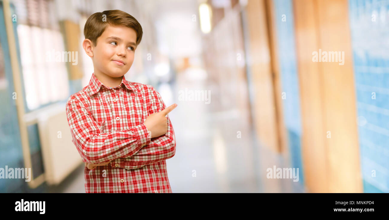 Handsome toddler child with green eyes pointing away side with finger ...