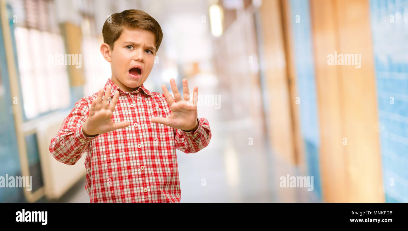 Handsome toddler child with green eyes disgusted and angry, keeping ...