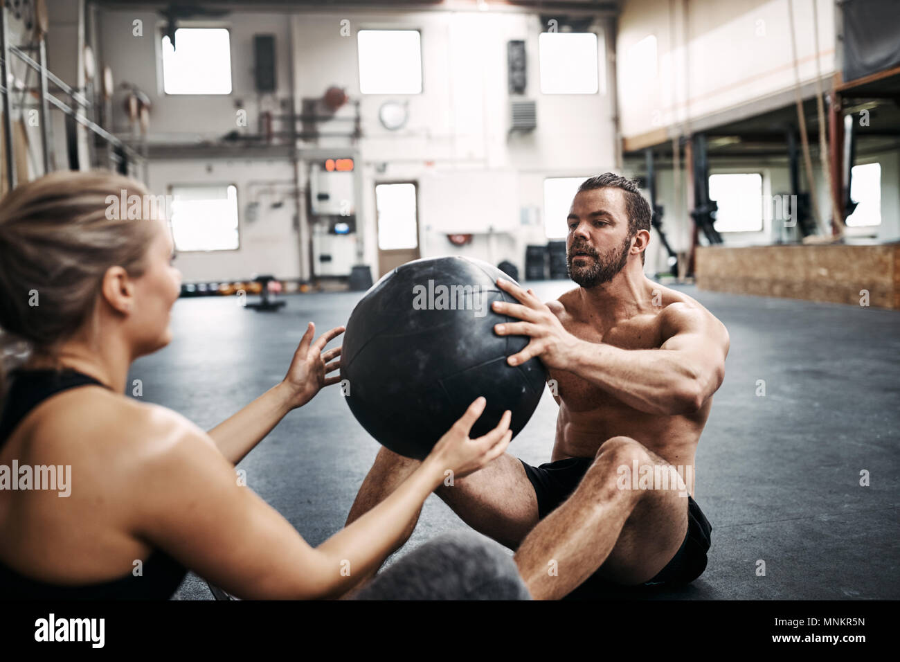 Two fit young people in sportswear exercising together with a medicine ...