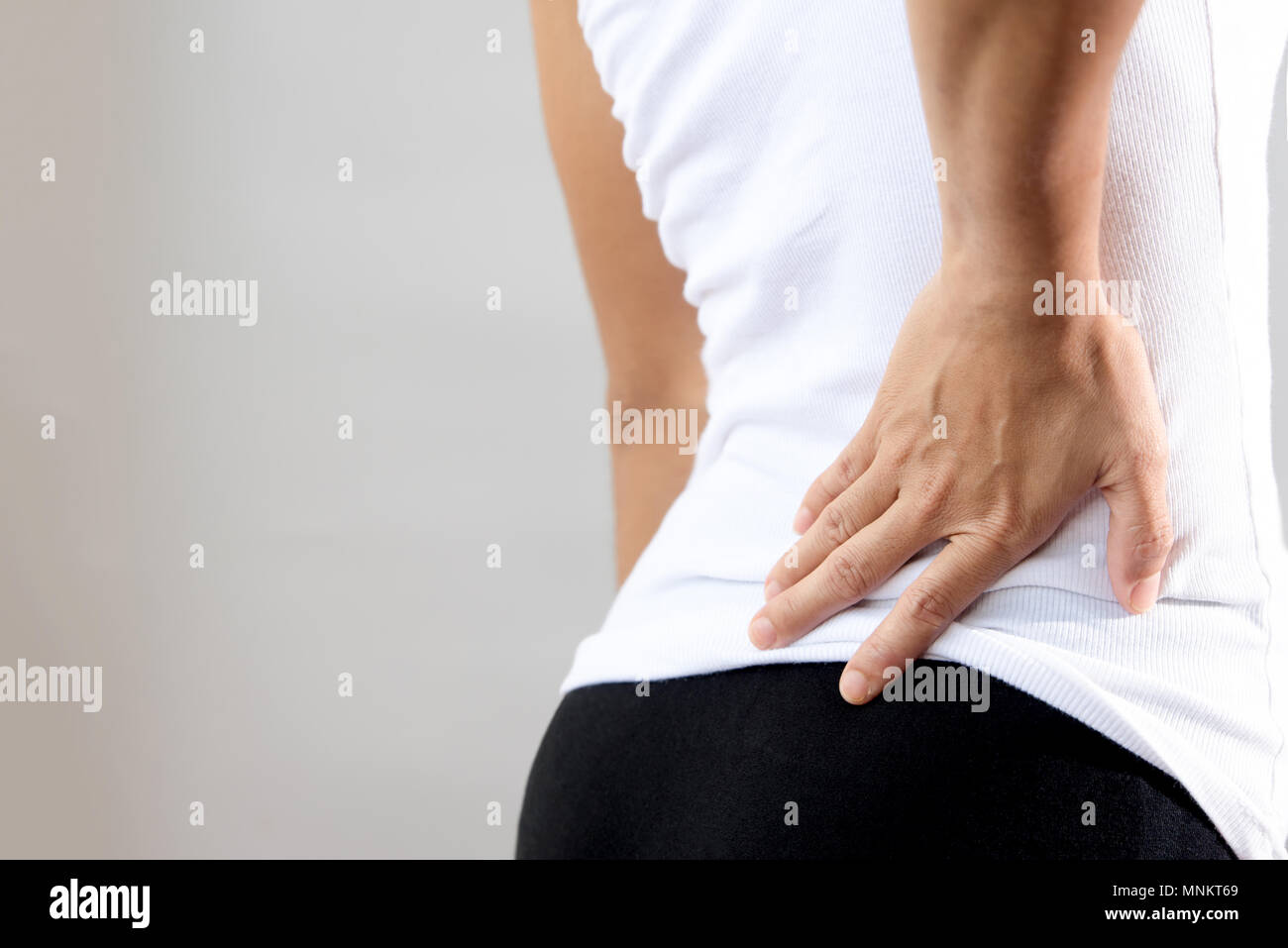 young woman pain at lower back, woman holding hand on lower back muscle ...