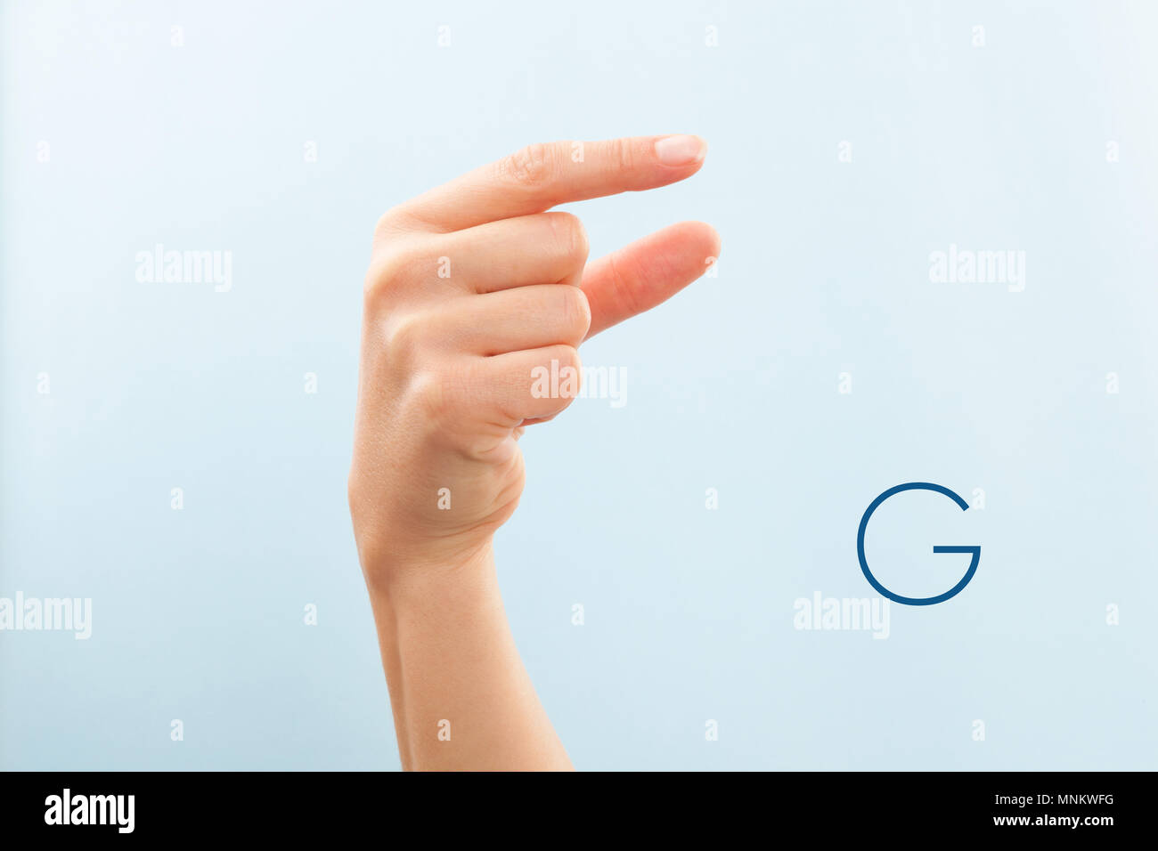 American sign language. Female hand showing letter G isolated on blue ...