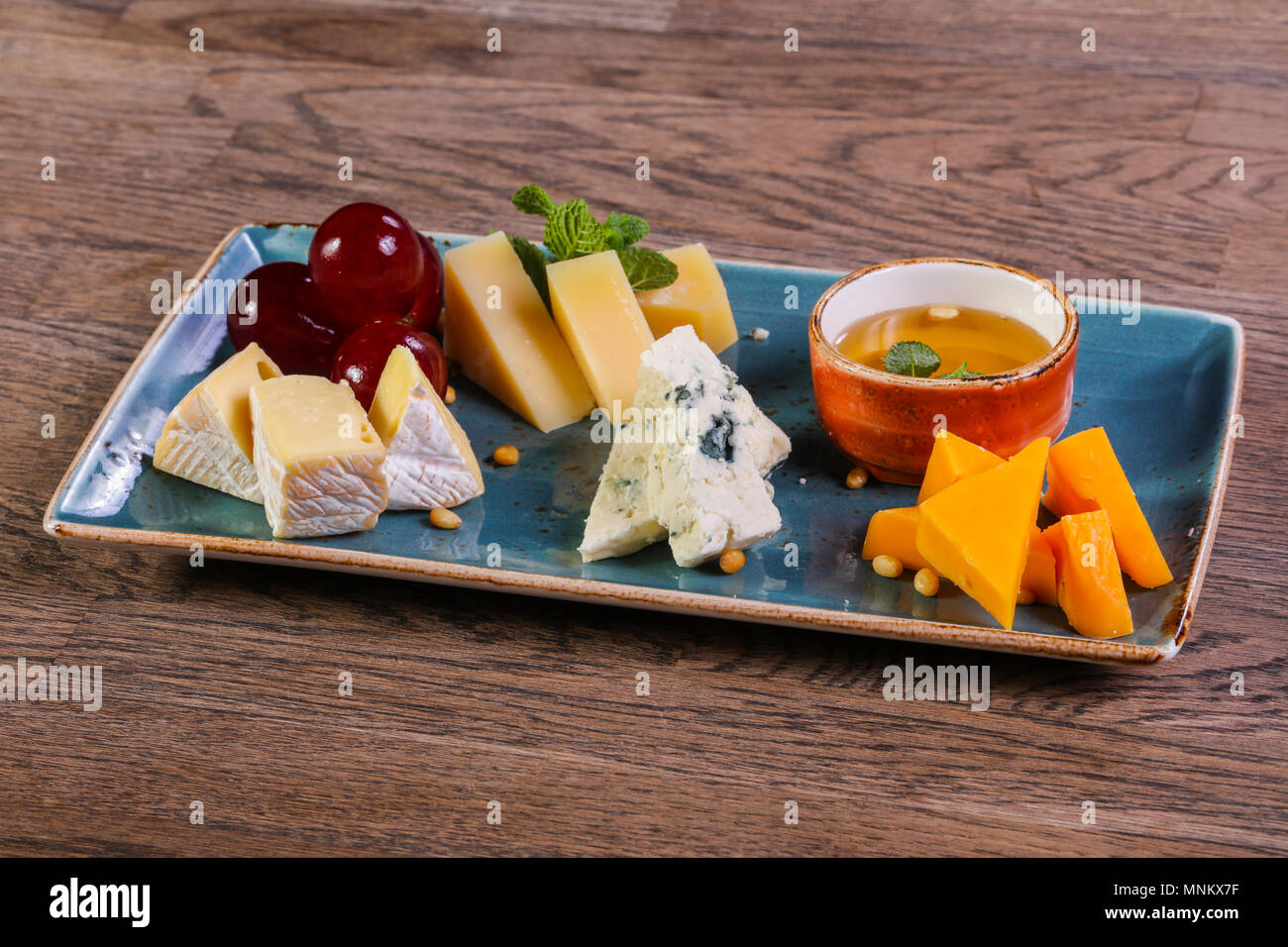 Cheese plate mix assortment with grape and honey Stock Photo - Alamy