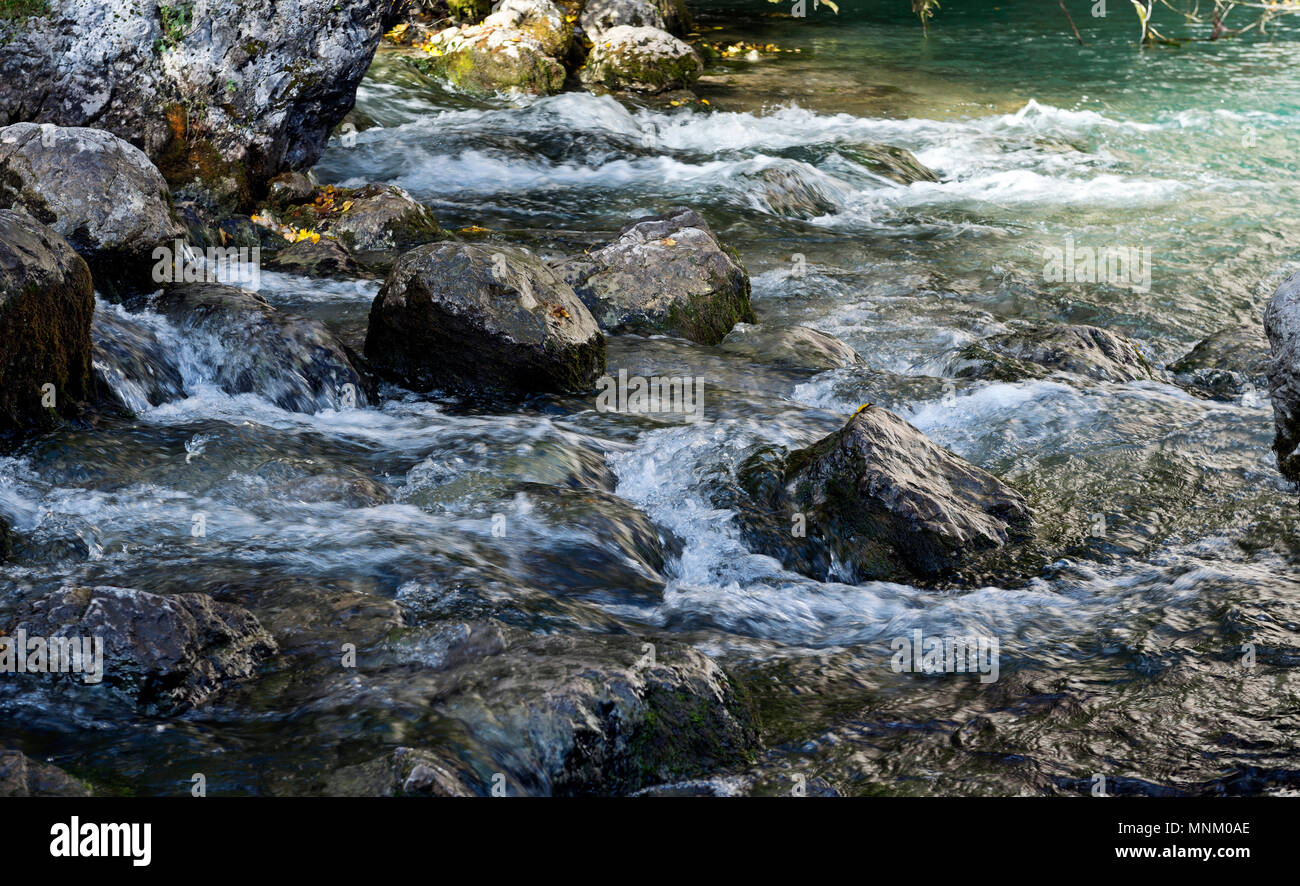 Fast water stream flowing between rocks in the riverbed Stock Photo - Alamy