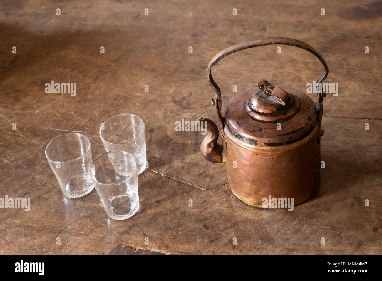 Still life with a beautiful worn retro style copper tea kettle with ...