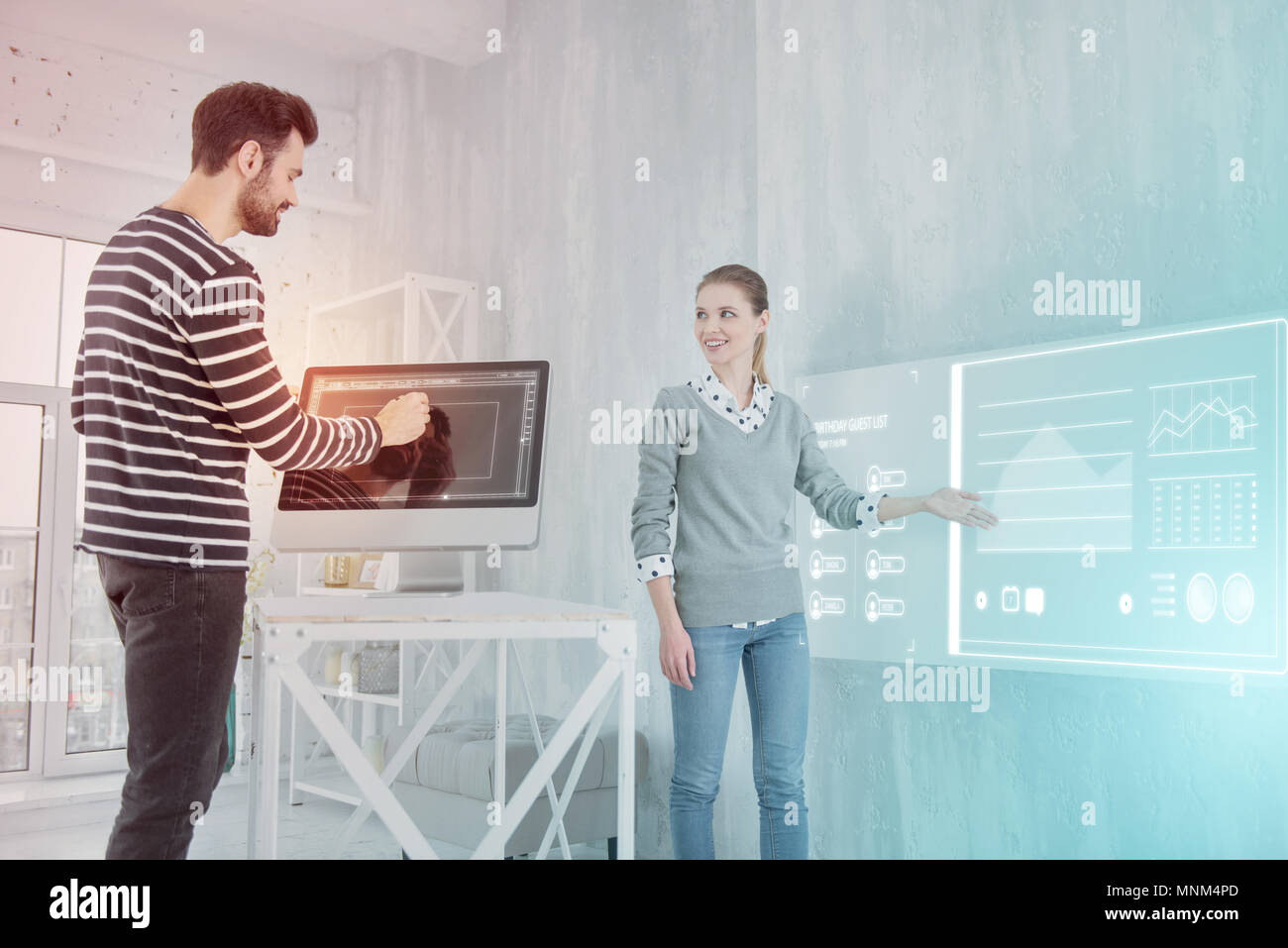 Smiling web designer showing a diagram while her colleague working ...