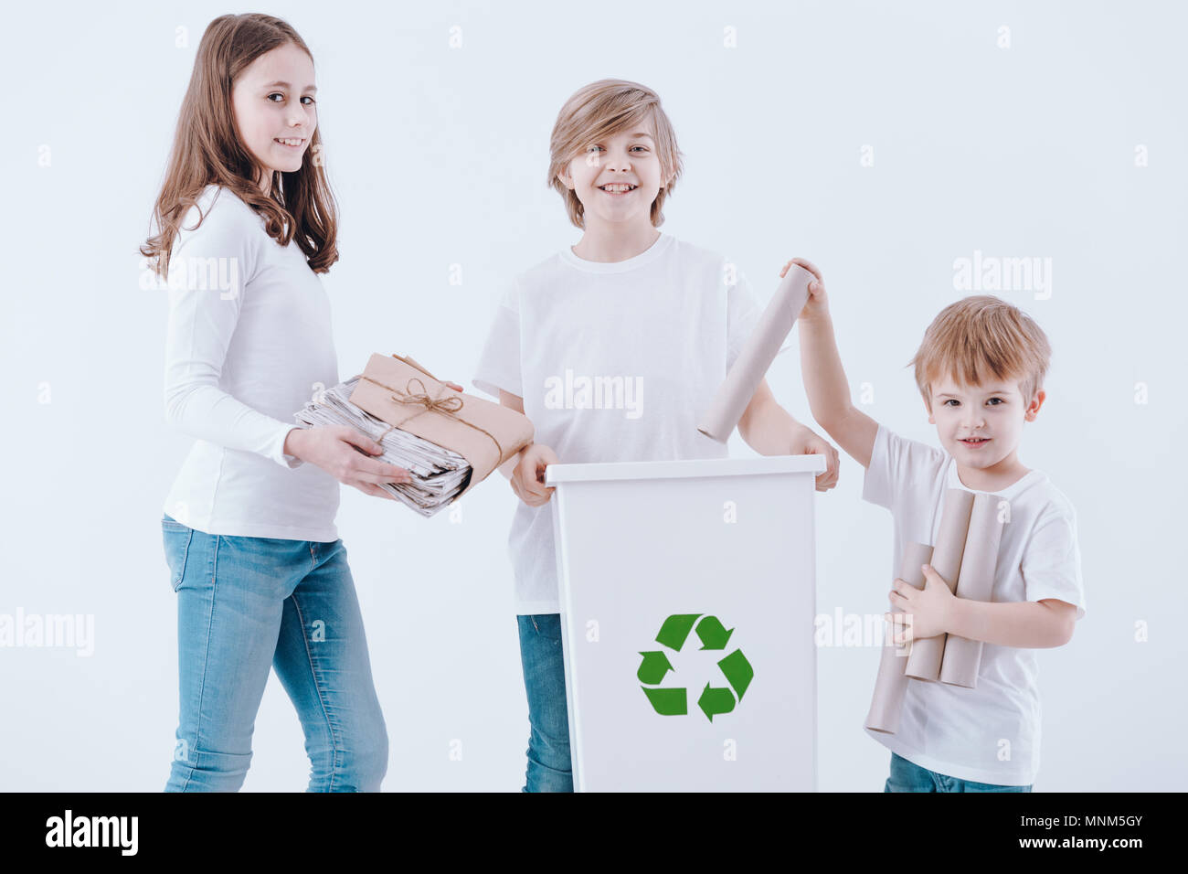 Smiling kids segregating paper waste into bin with green symbol Stock ...