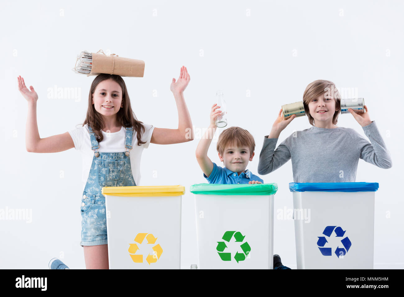 Happy children having fun while segregating household waste into bins ...