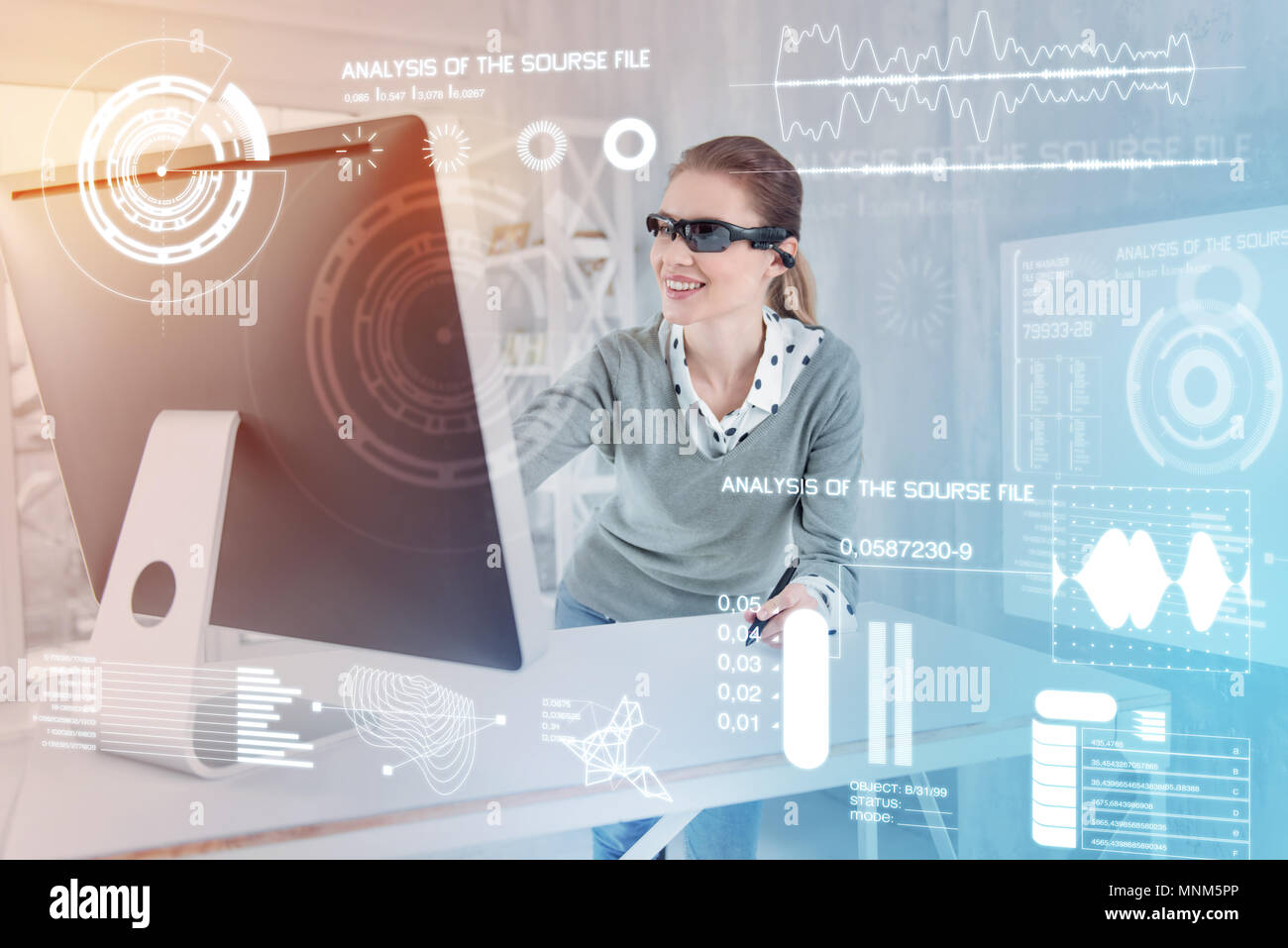 Positive designer smiling while looking at the screen of her convenient ...