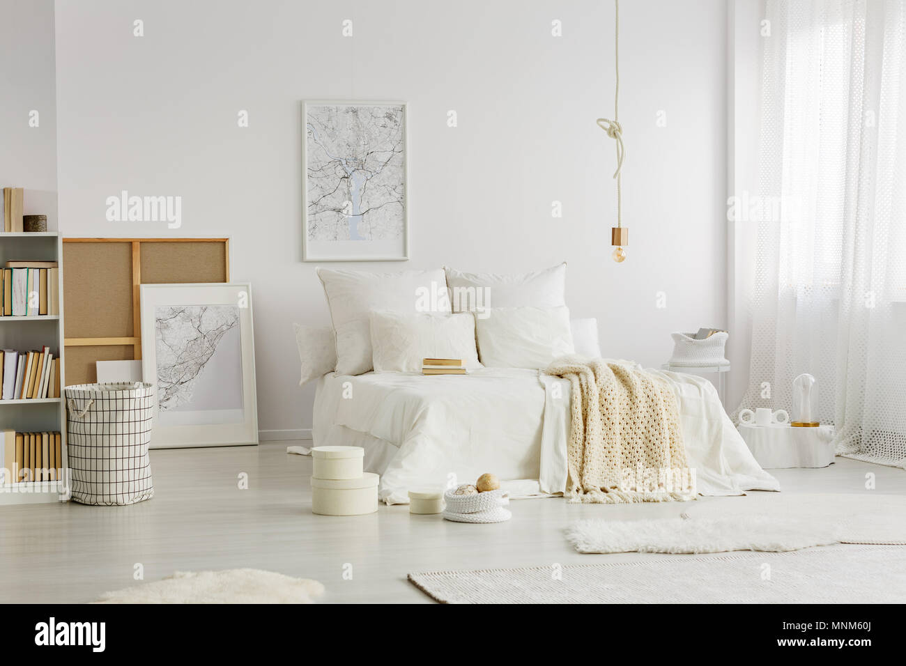 Two simple map posters placed in white bedroom interior with books ...
