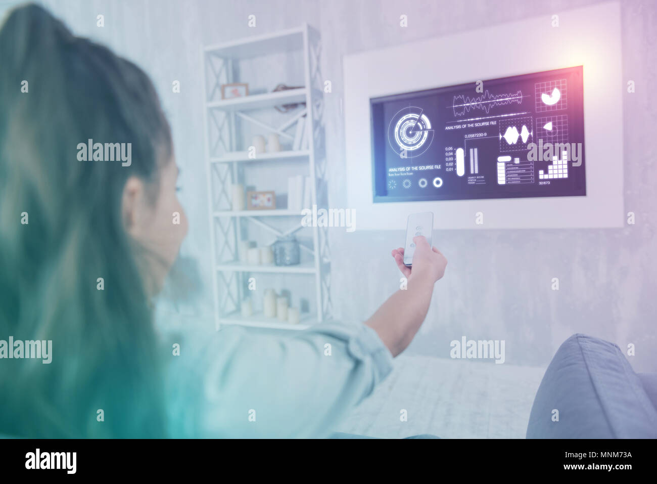 Calm child sitting at home and switching channels Stock Photo - Alamy
