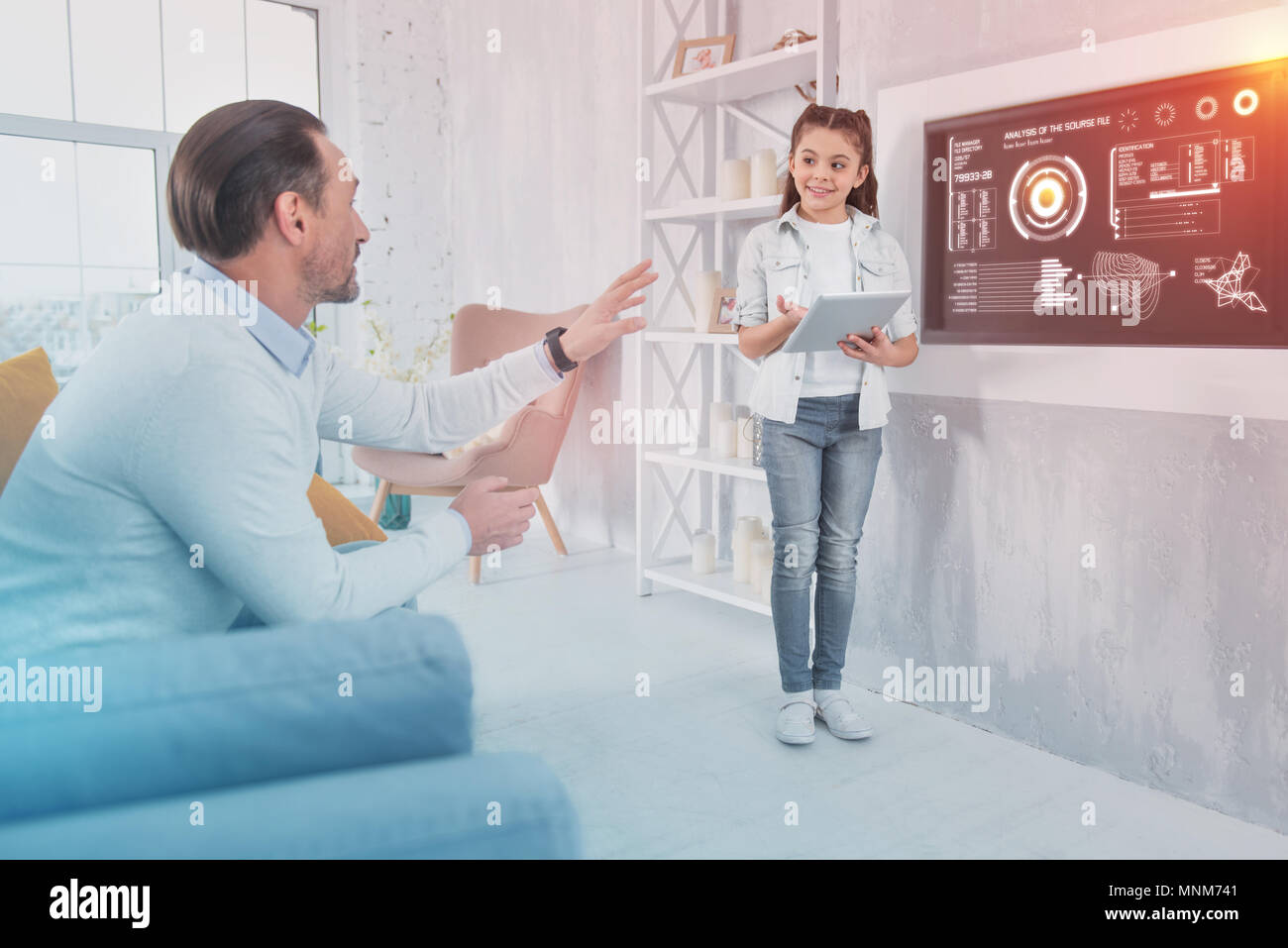 Attentive parent talking to his clever daughter while checking her ...