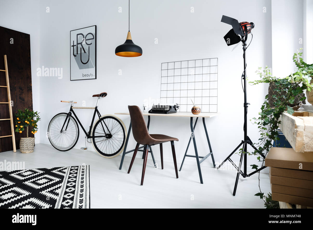 Simple, white home workspace with desk, lamp, chair, bike, plants Stock ...