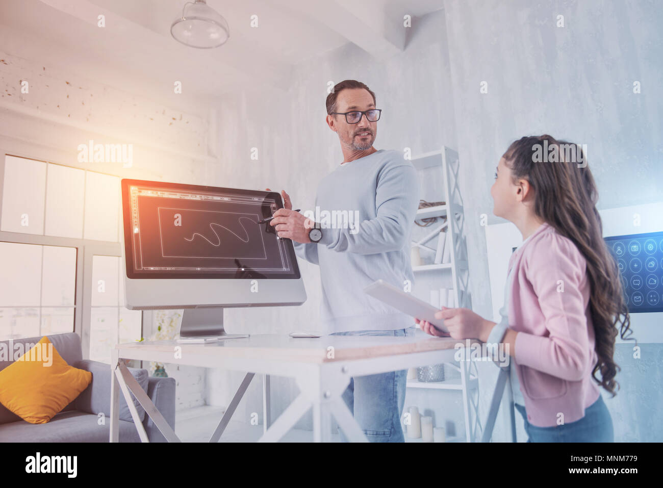 Calm teacher drawing patterns and a girl looking at him Stock Photo - Alamy