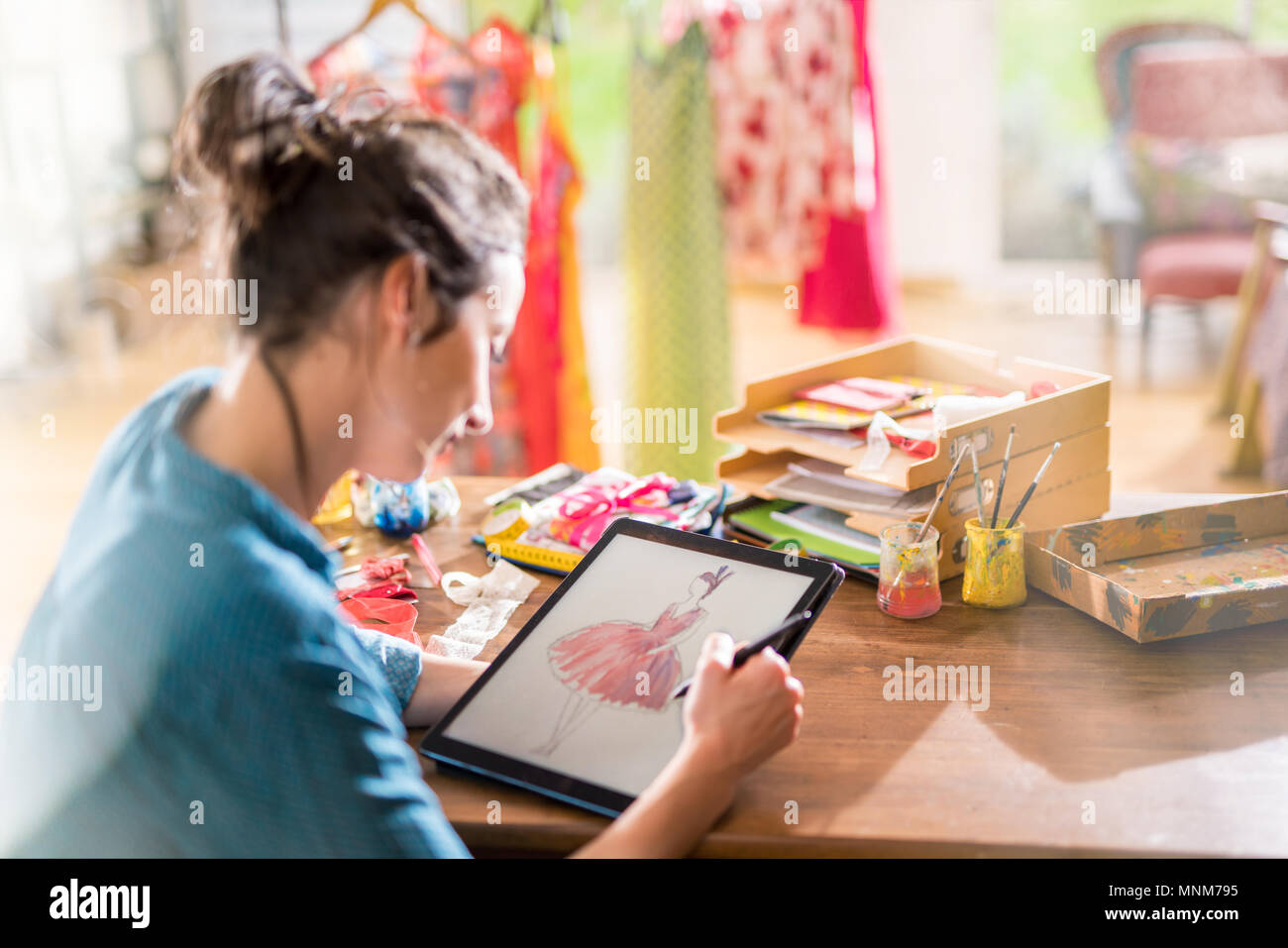 Fashion designer drawing a new model on a digital tablet Stock Photo ...