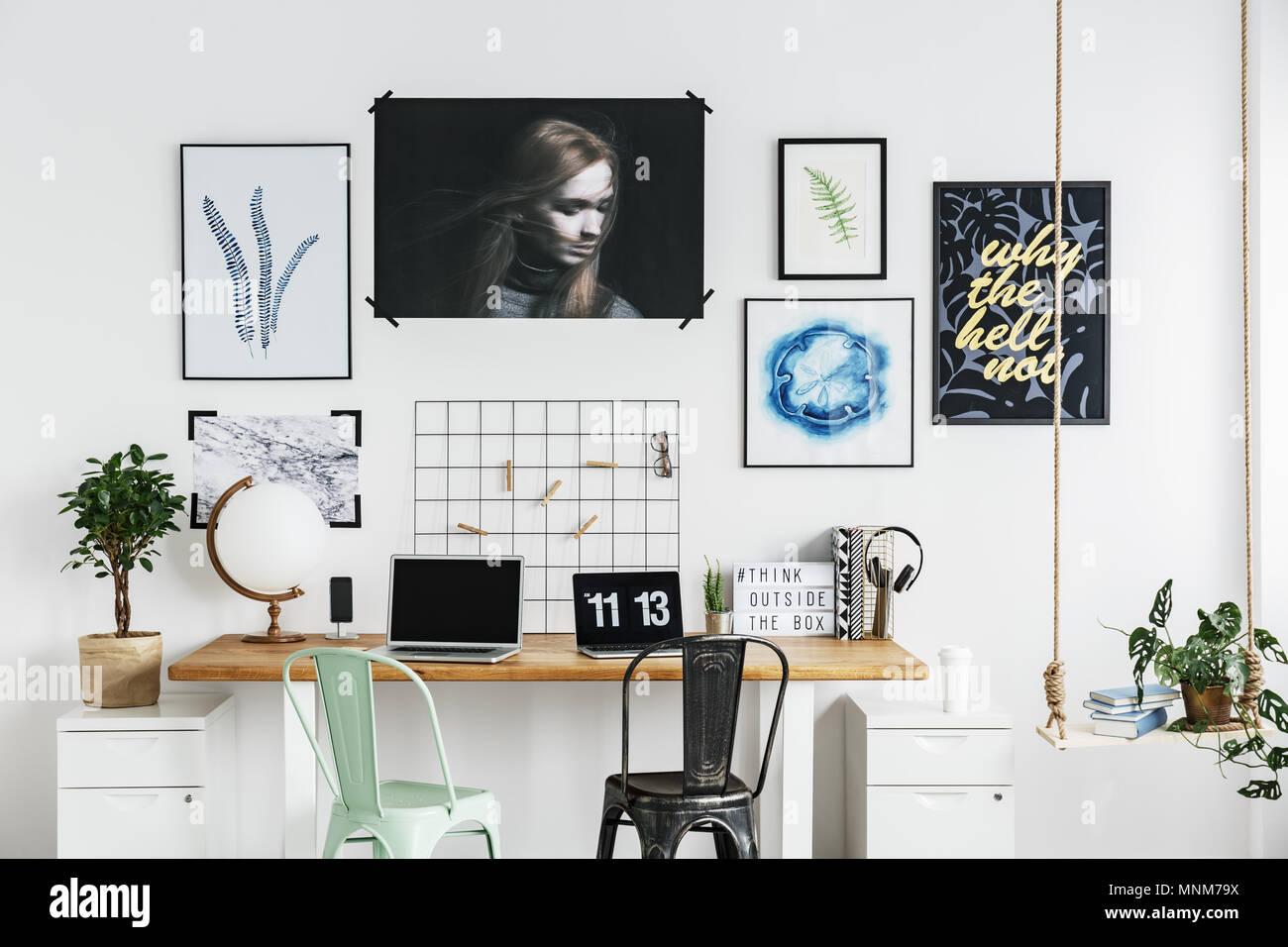 Posters on a white wall in modern home office Stock Photo - Alamy