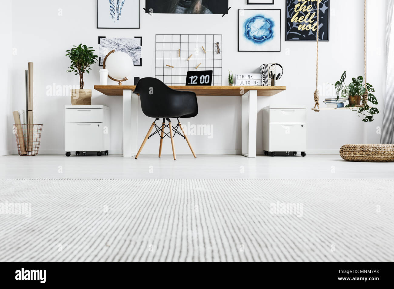 Spacious hipster home office with desk, posters and swing Stock Photo ...