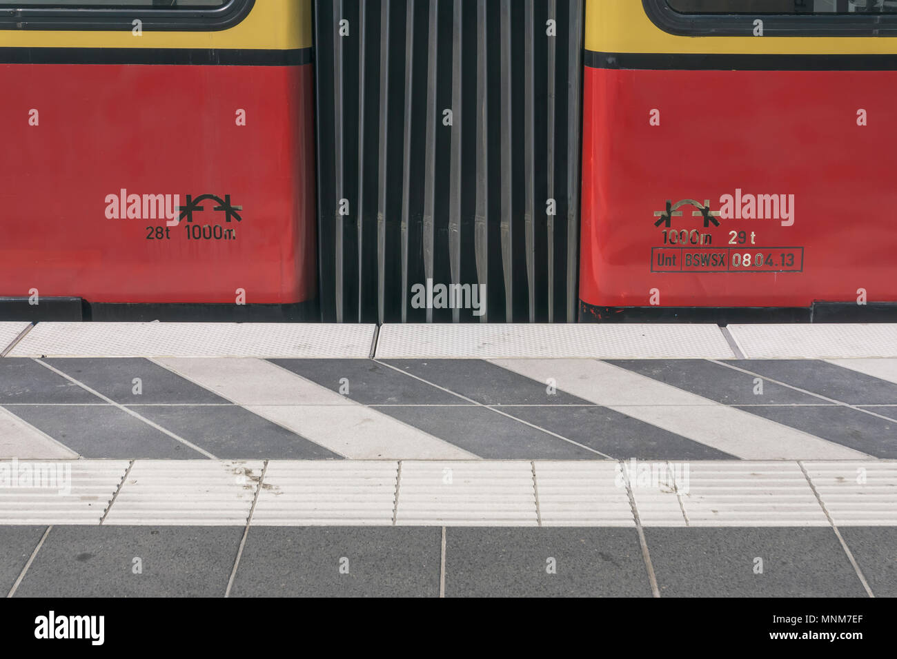 Close-up of commuter train and platform at station Stock Photo - Alamy