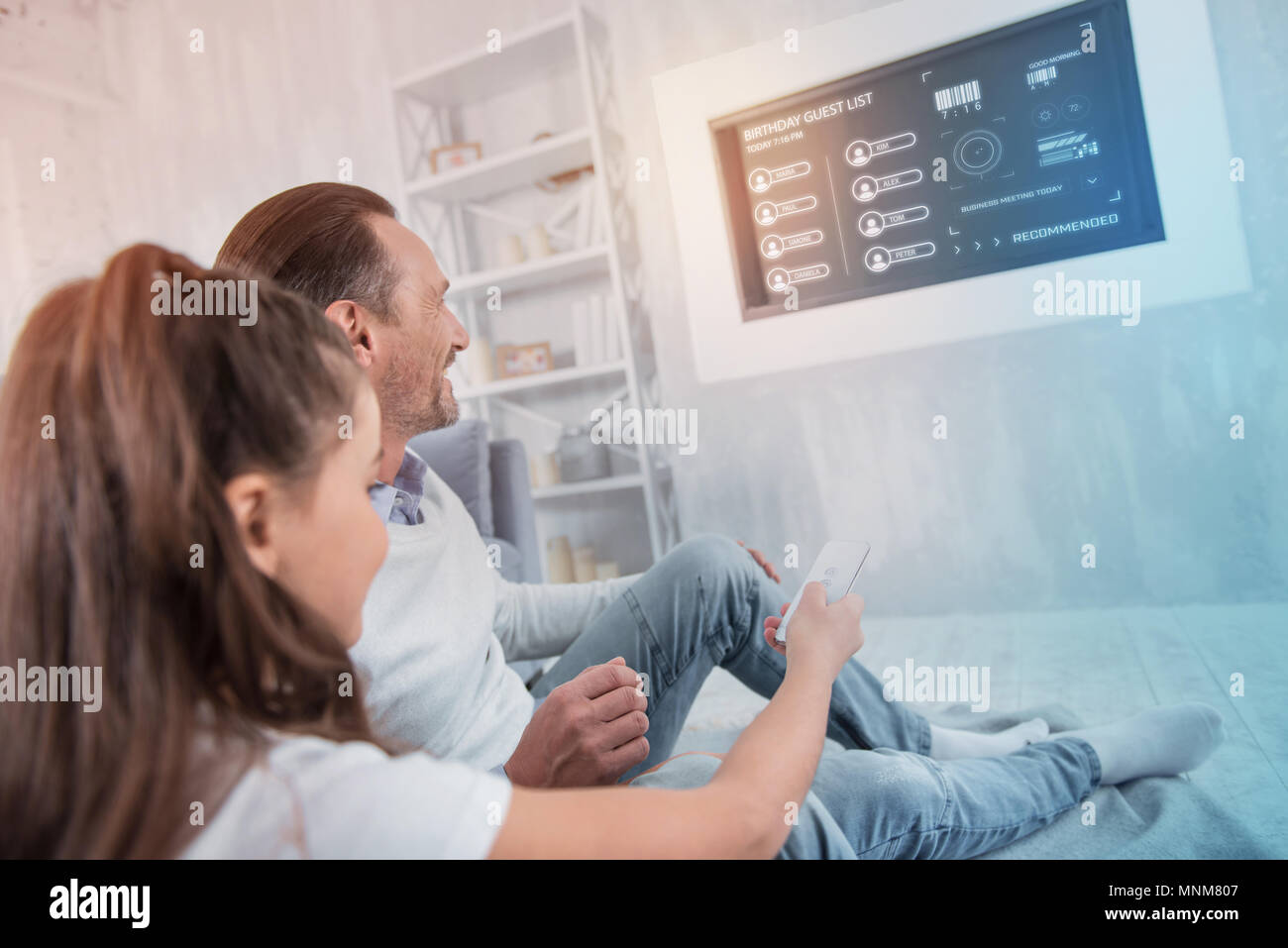 Young father smiling while his daughter holding a remote control Stock ...