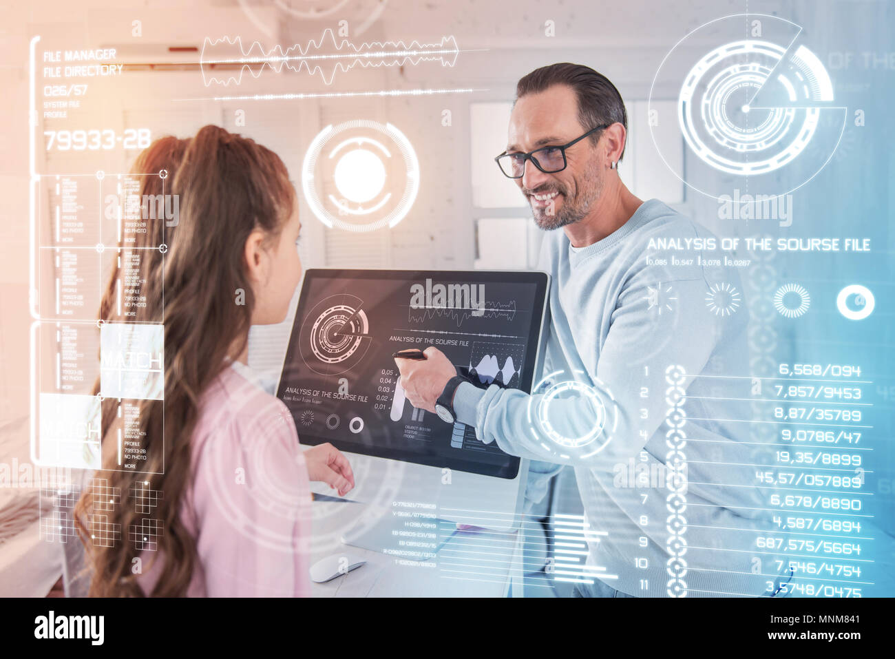 Cheerful programmer smiling and showing a modern stylus to his daughter ...