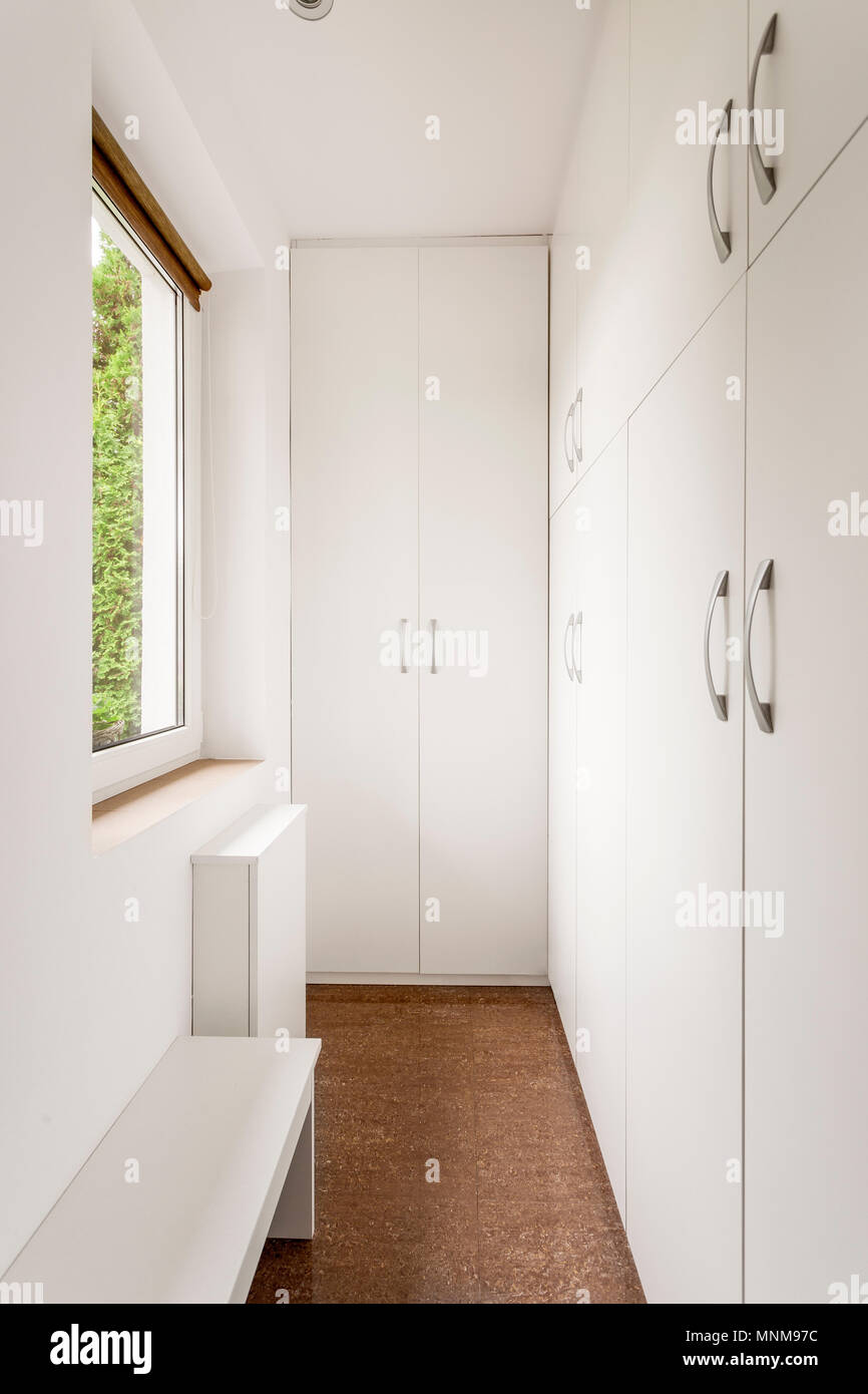 Small storage room with simple white furniture and window Stock Photo ...