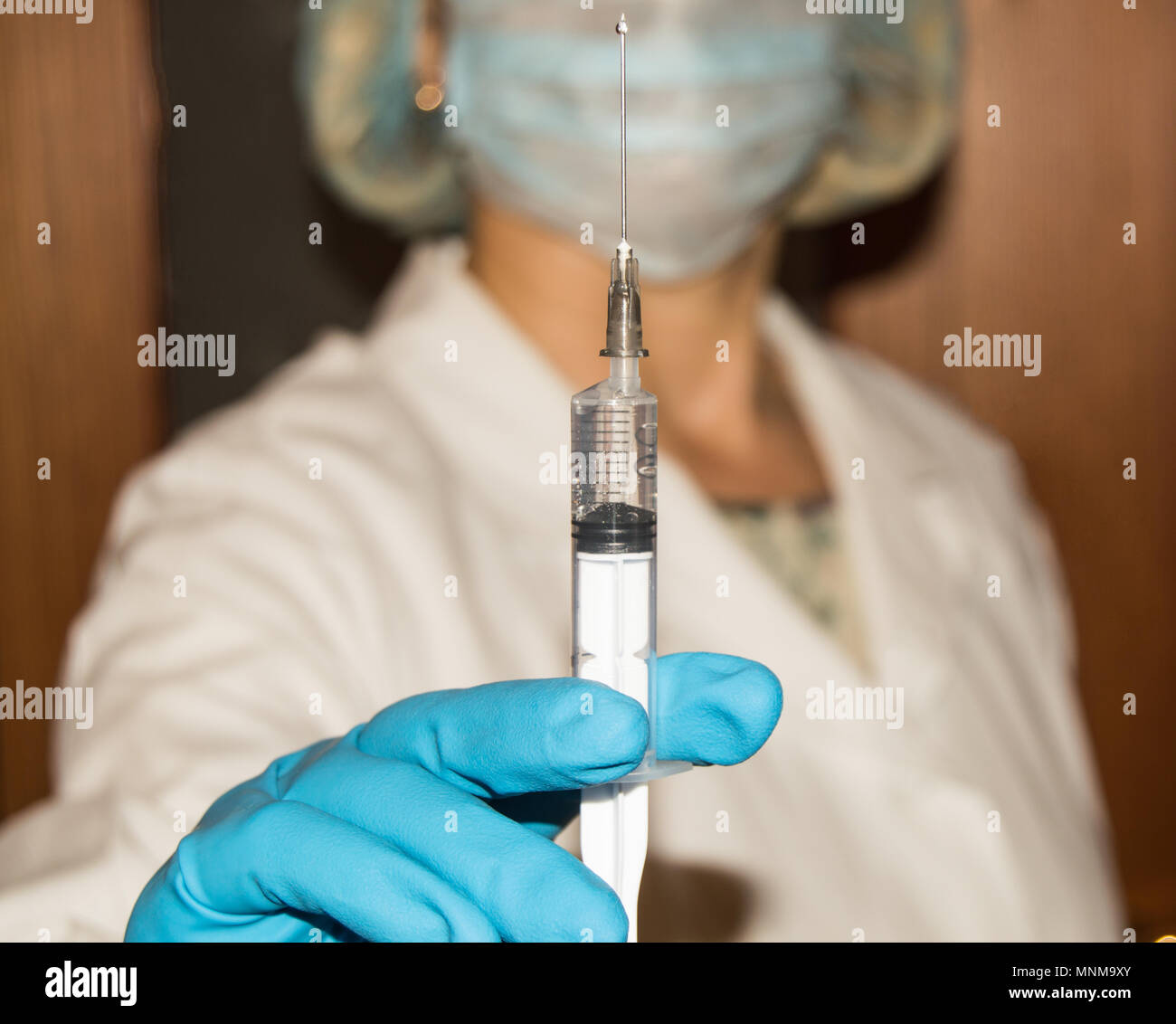 Professional doctor woman with medical syringe in hands, getting ready ...