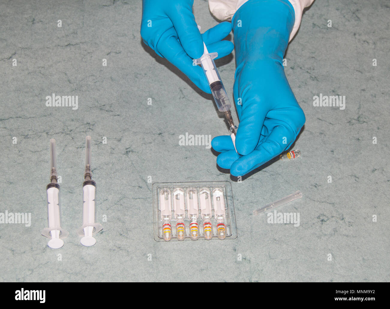 Nurse gaining medication from the vial into the medical syringe for ...