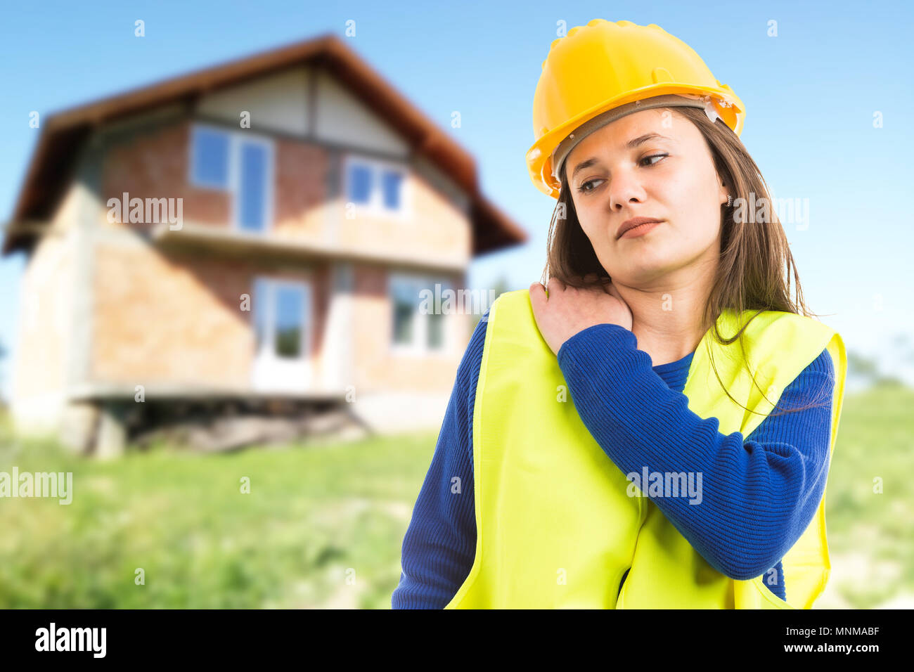 Young female engineer or architect having shoulder pain as exhausted ...