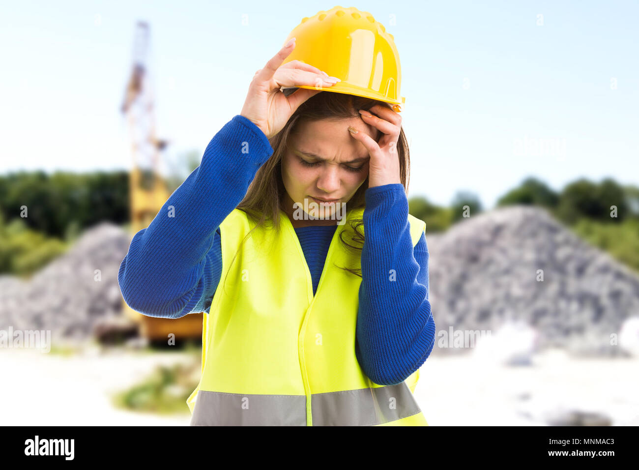 Young female engineer or architect suffering headache because of ...