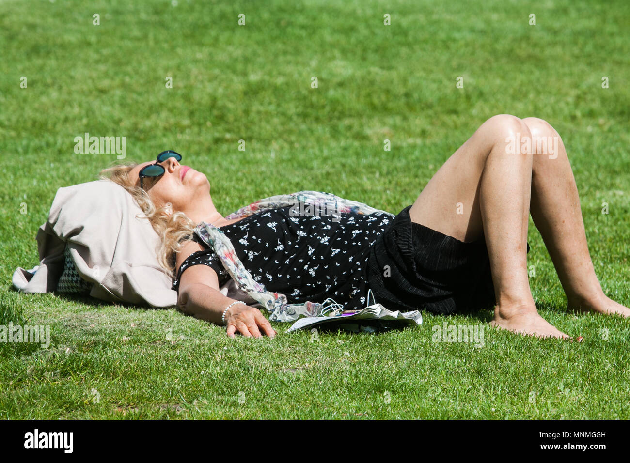 London UK. 18th May 2018. A woman sunbathing in the warm spring ...