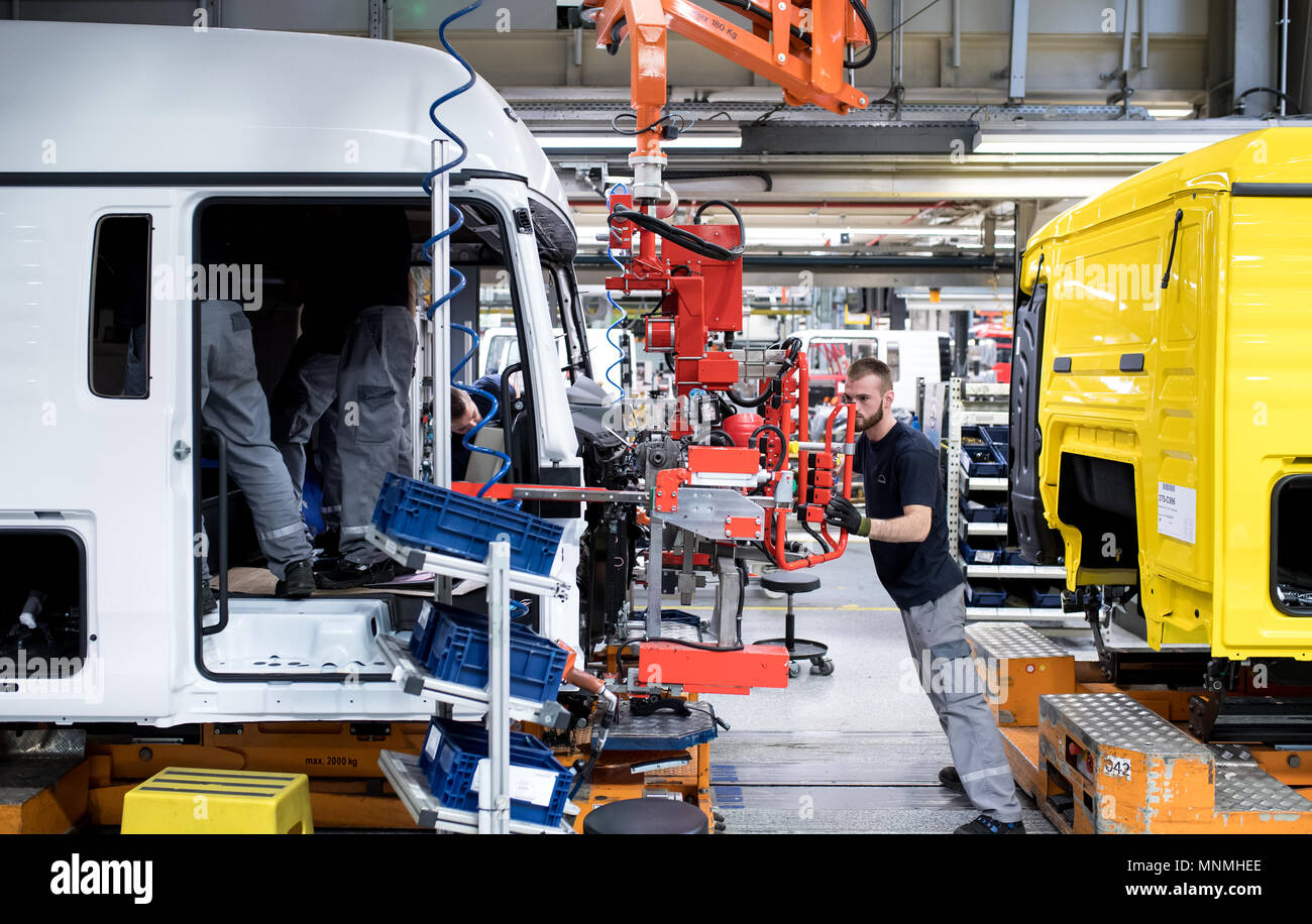 16 May 2018, Germany, Munich: Employees of MAN Truck & Bus work on a ...
