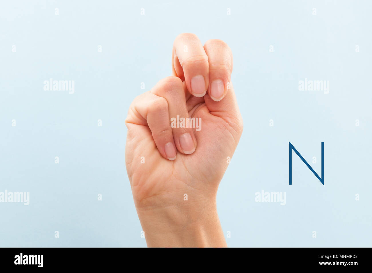 American sign language. Female hand showing letter N isolated on blue ...