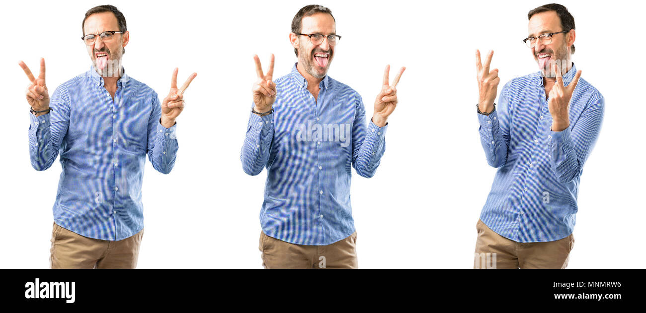 Middle age handsome man looking at camera showing tong and making ...