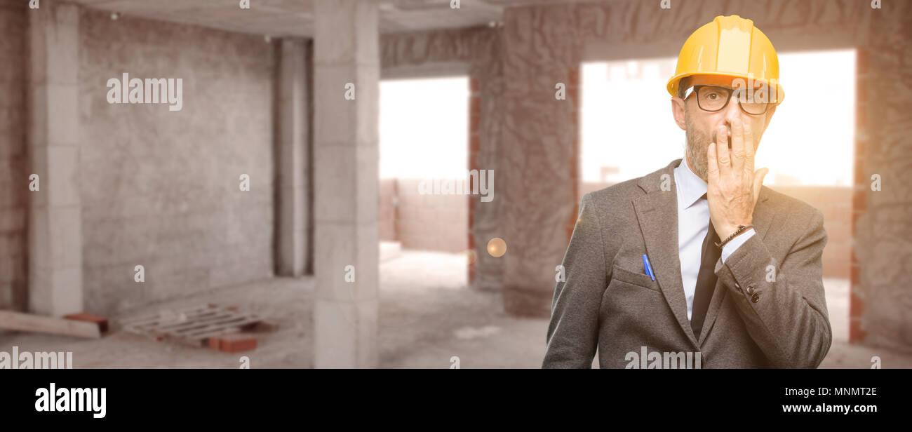 Senior architect or engineer covers mouth in shock, looks shy ...