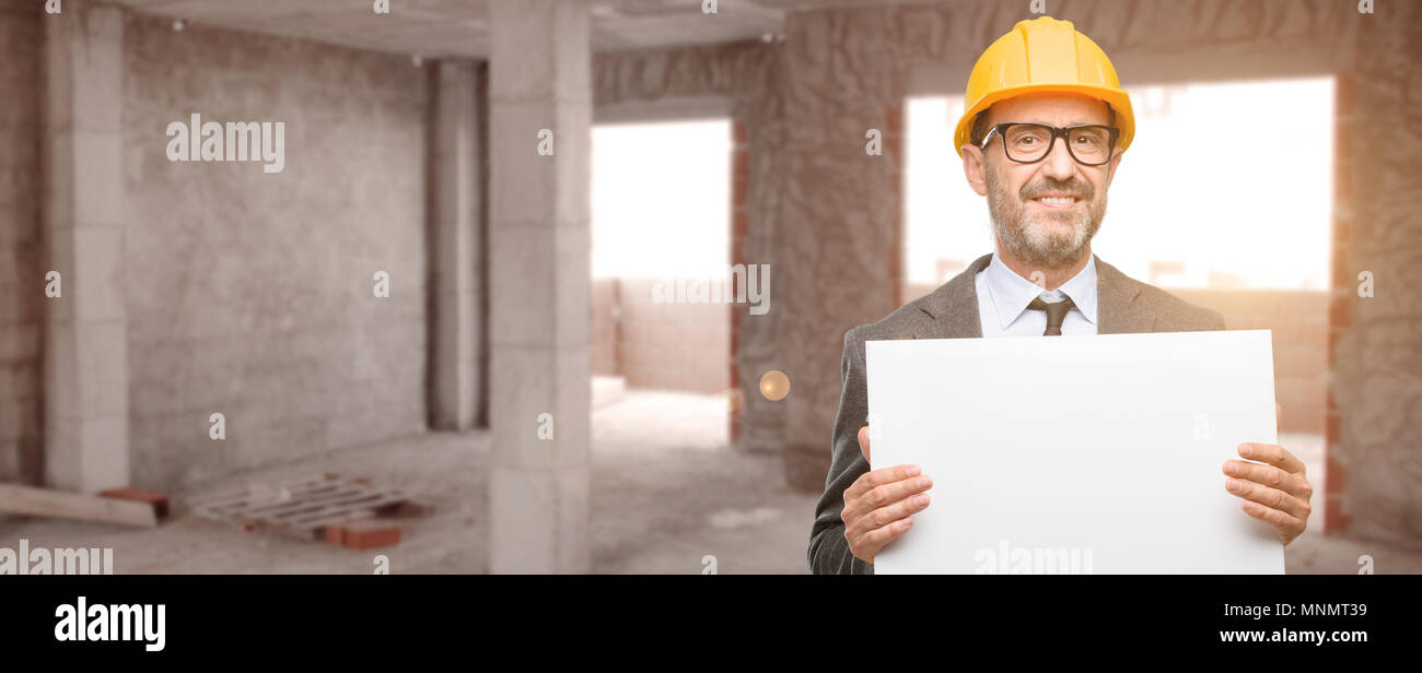 Senior architect or engineer holding blank advertising banner, good ...