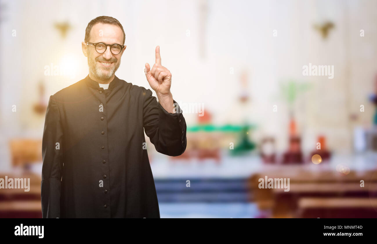 Priest religion man raising finger, the number one at church Stock ...