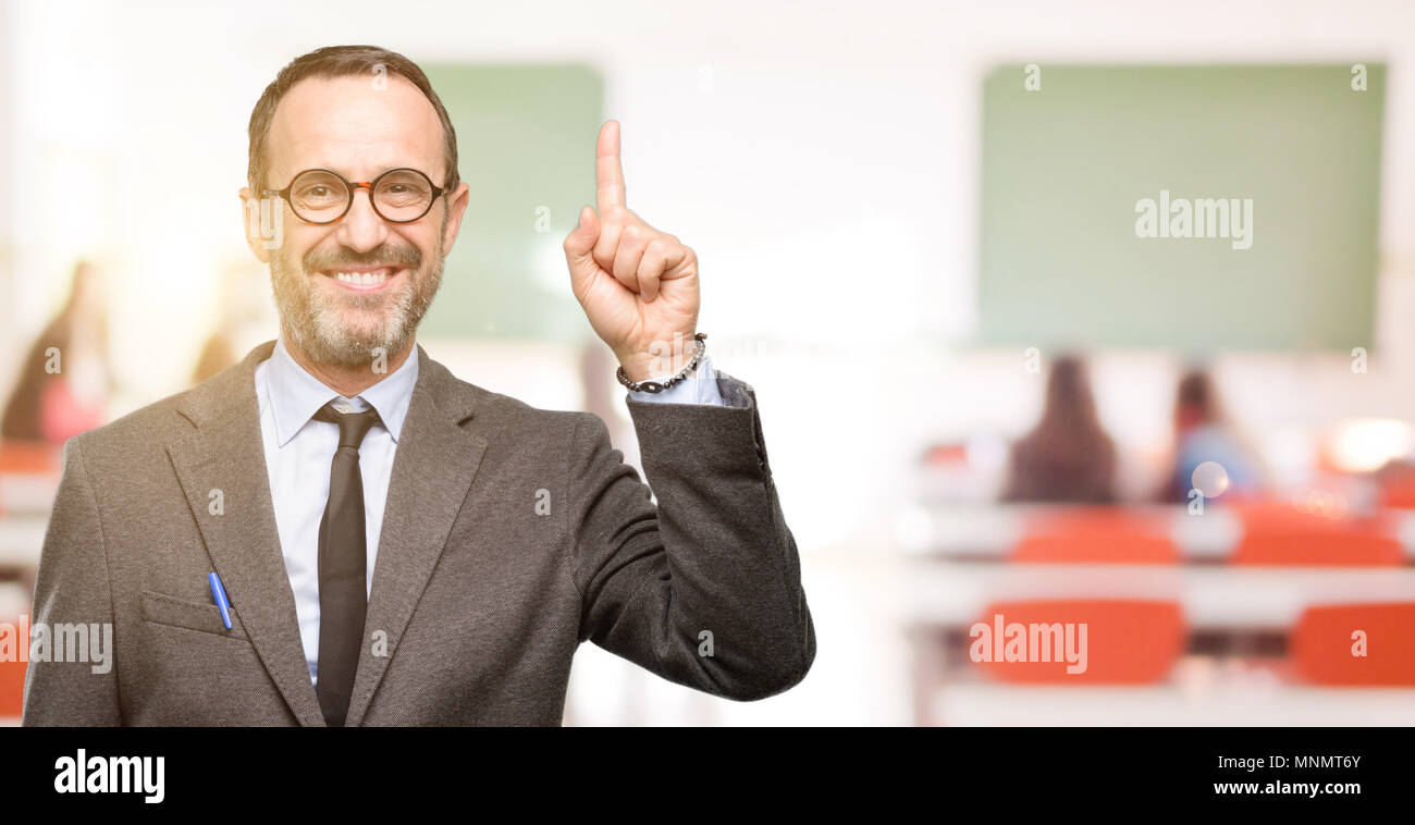 Teacher man using glasses raising finger, the number one at classroom ...