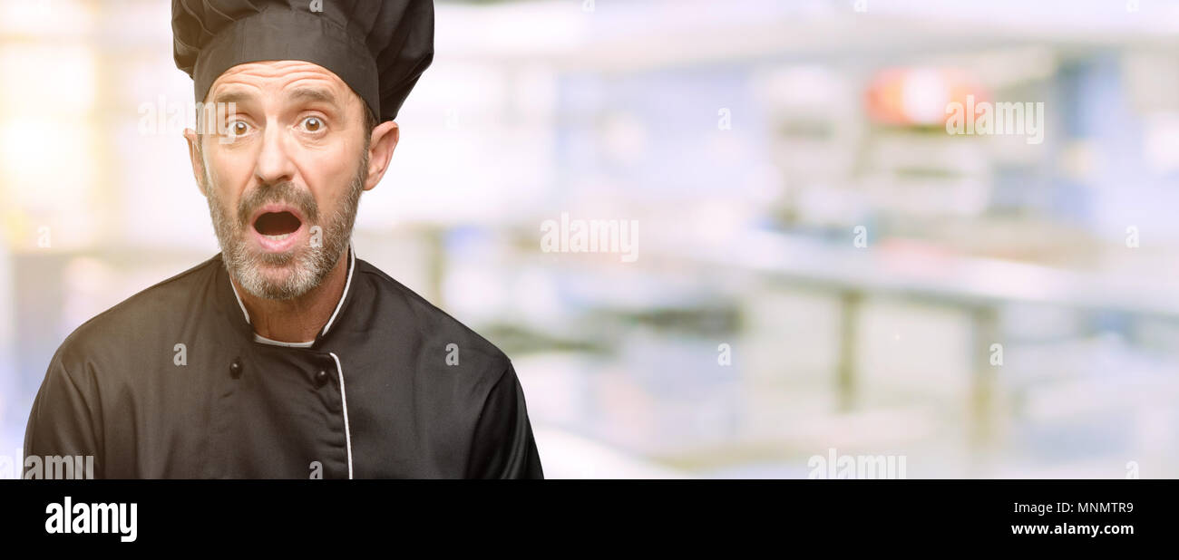 Senior cook man, wearing chef hat scared in shock, expressing panic and ...