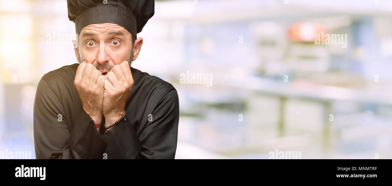 Senior cook man, wearing chef hat terrified and nervous expressing ...