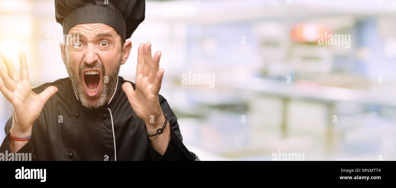 Senior cook man, wearing chef hat stressful keeping hands on head ...