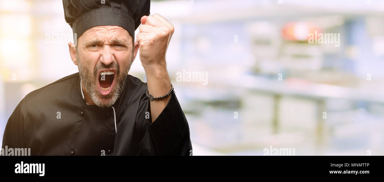 Senior cook man, wearing chef hat irritated and angry expressing ...