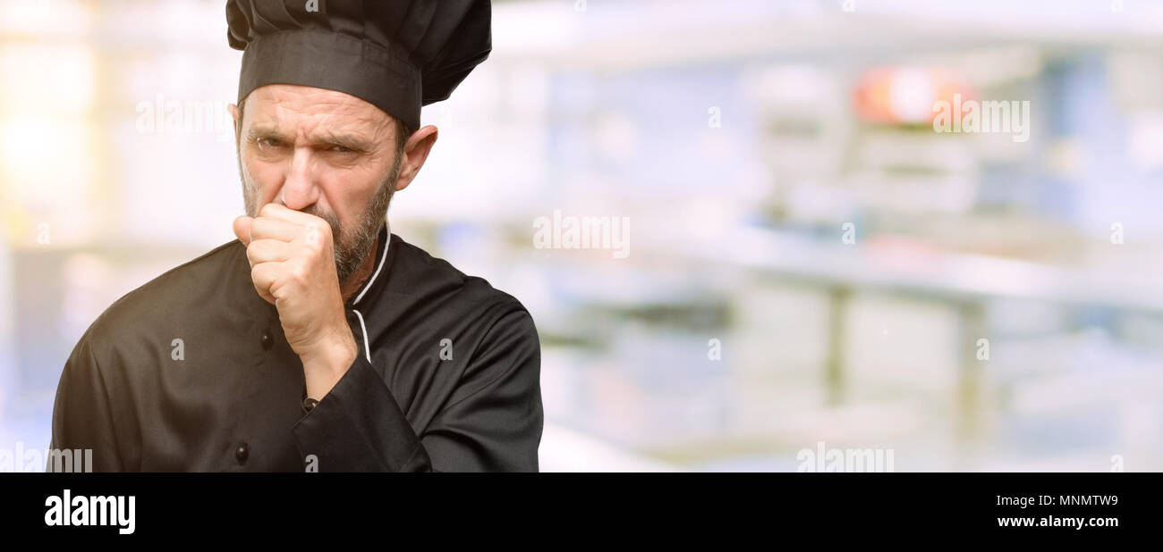 Senior cook man, wearing chef hat sick and coughing, suffering asthma ...