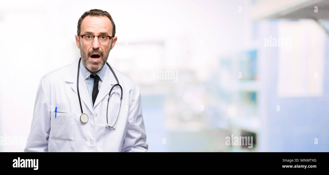 Doctor senior man, medical professional scared in shock, expressing ...
