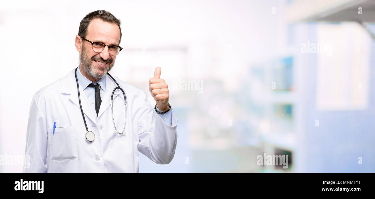 Doctor senior man, medical professional smiling broadly showing thumbs ...