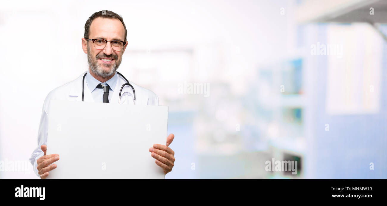 Doctor senior man, medical professional holding blank advertising ...