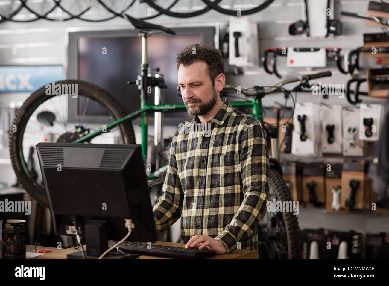Small business owner using computer in a store Stock Photo - Alamy