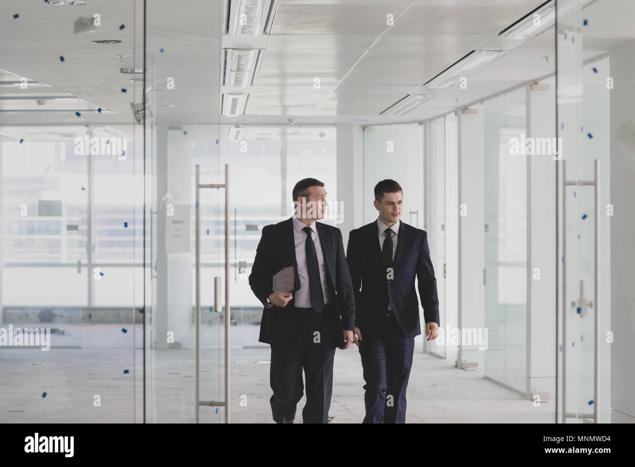 Businessmen looking at new office space Stock Photo - Alamy