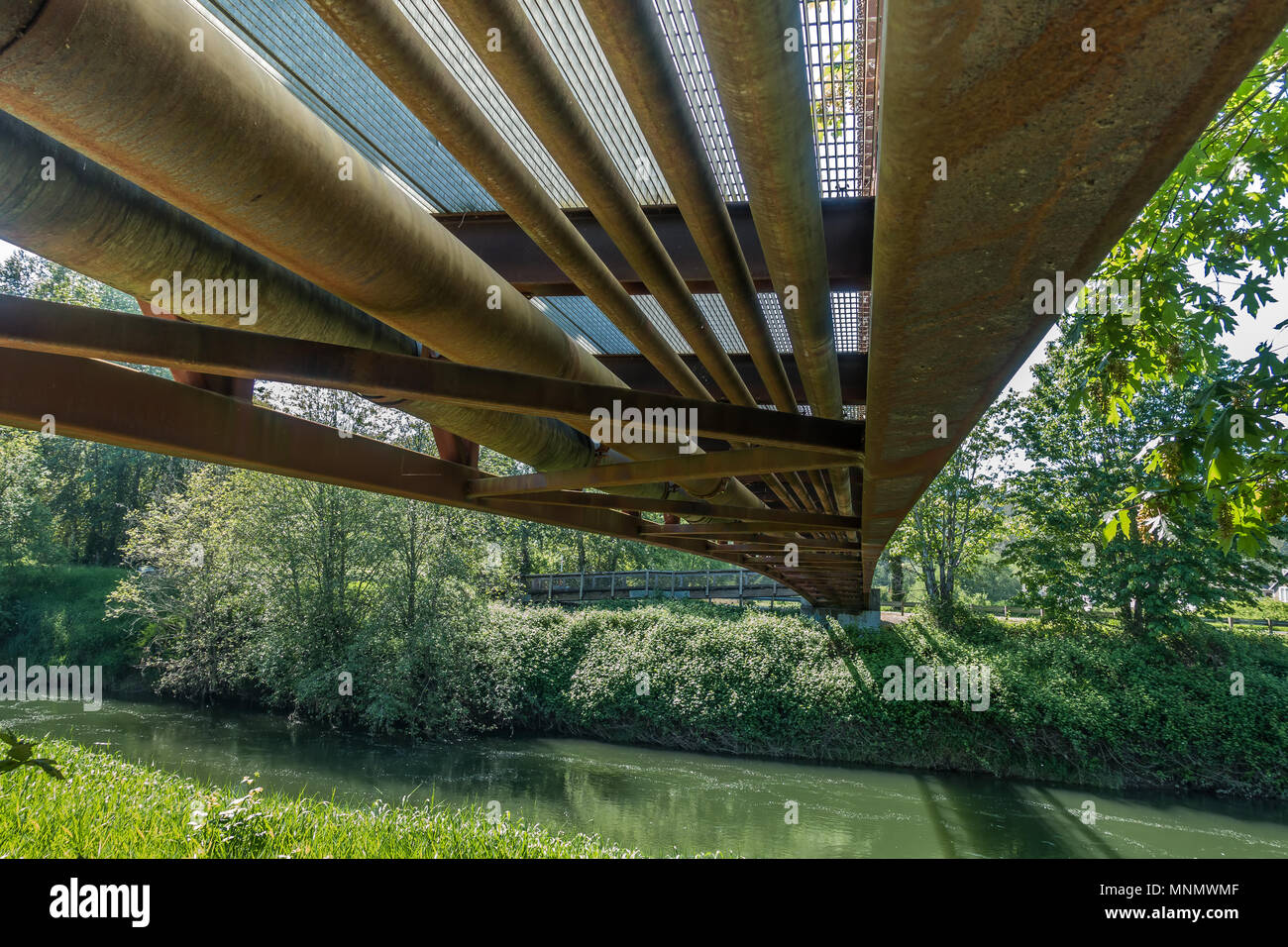 A view from beneath a rusty metal walking bridge that spans the Green ...