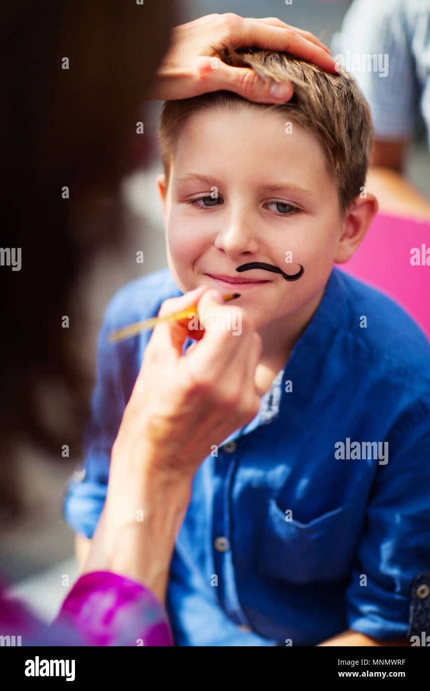 Portrait of a cute little boy with mustache painted on his face Stock ...